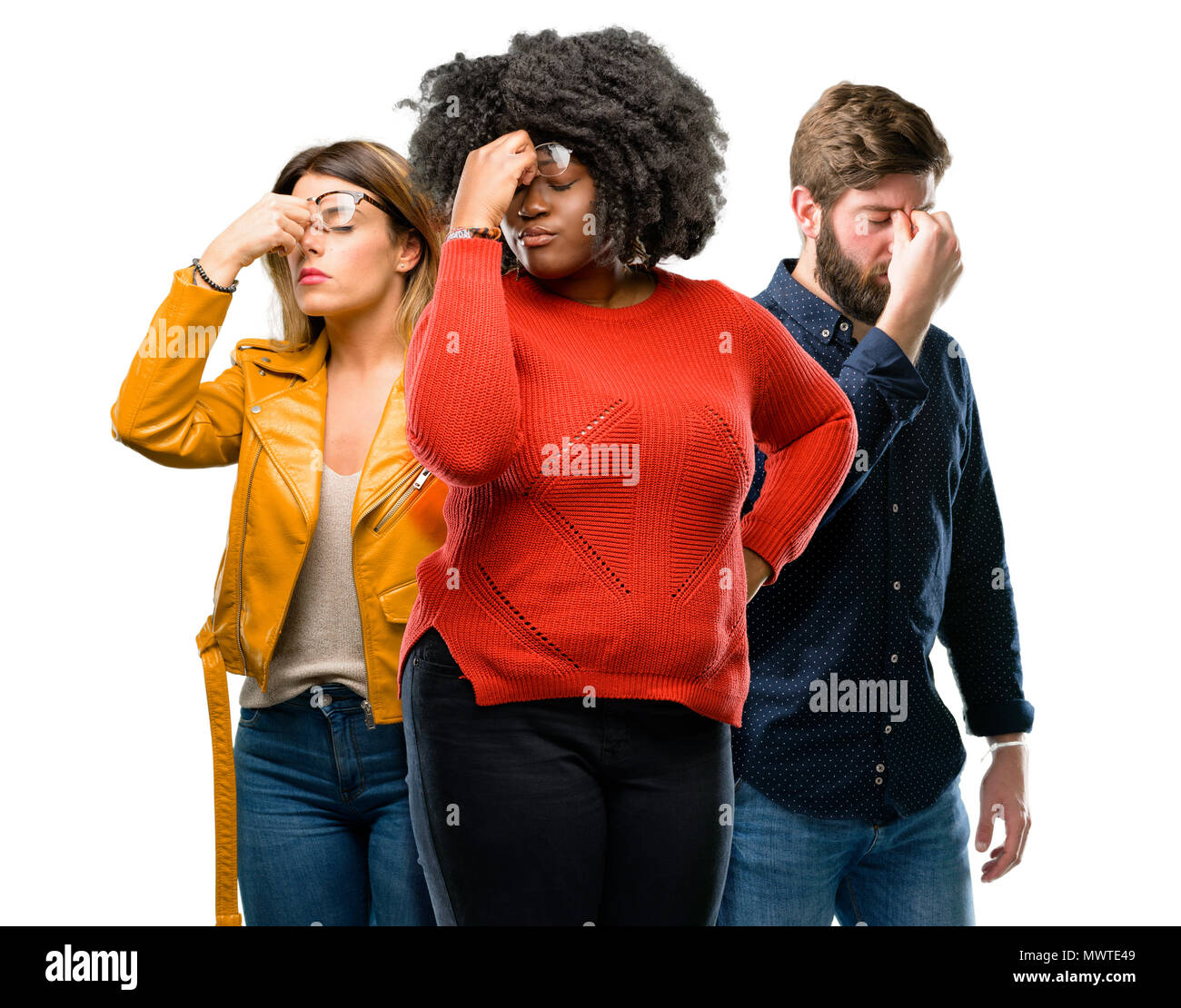 Group of three young men and women with sleepy expression, being ...