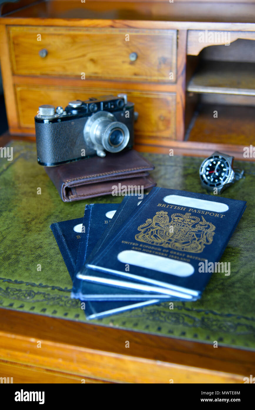 antique desk with passports and old leica camera, watch with names ...