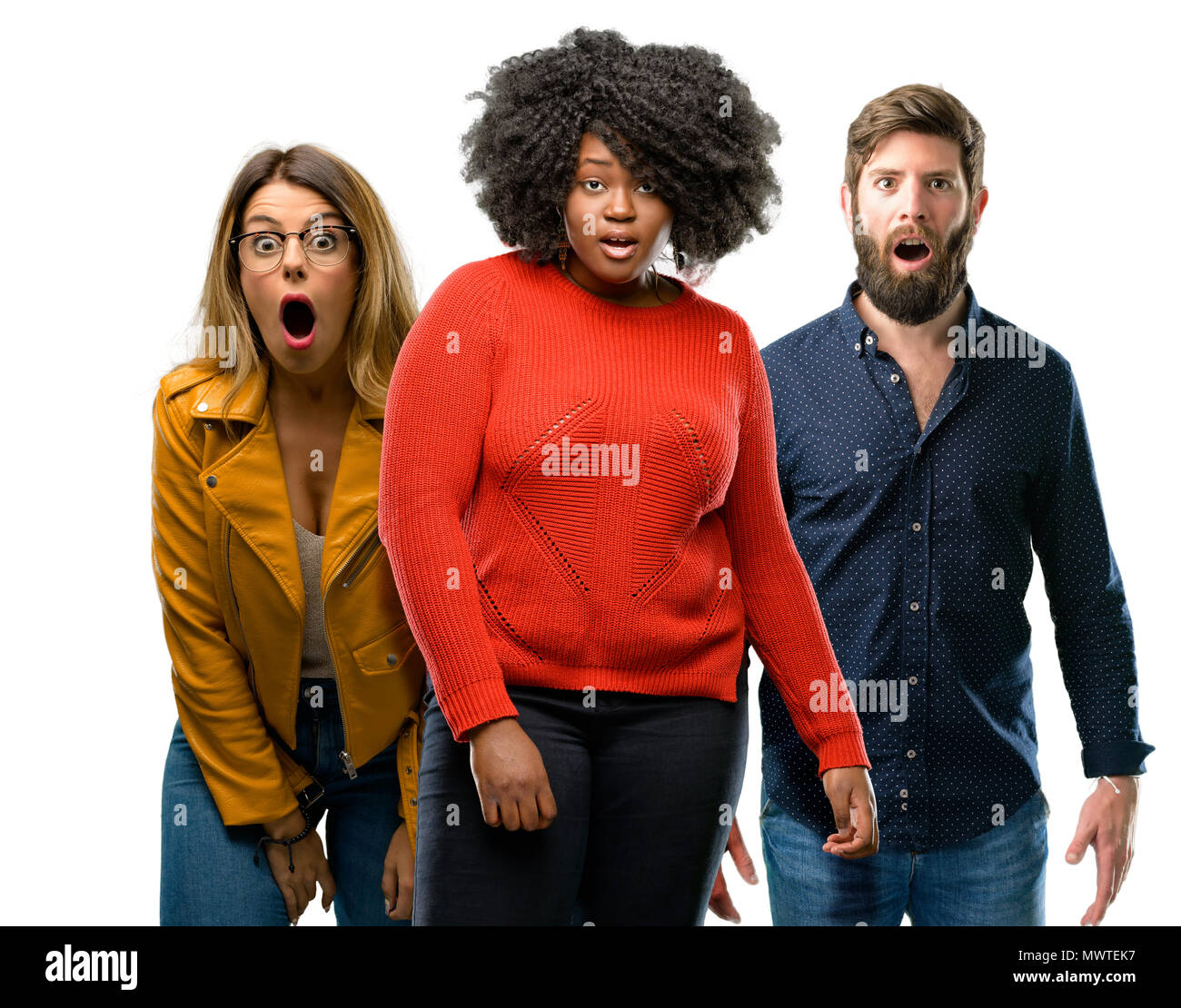 Group of three young men and women scared and surprised cheering ...