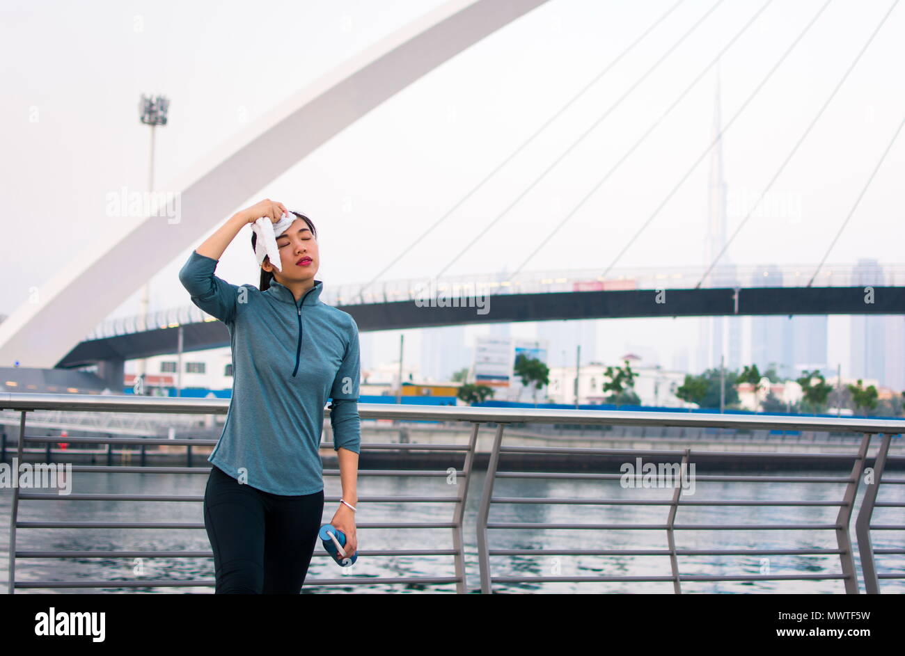 Tired girl wiping out sweat after workout Stock Photo - Alamy