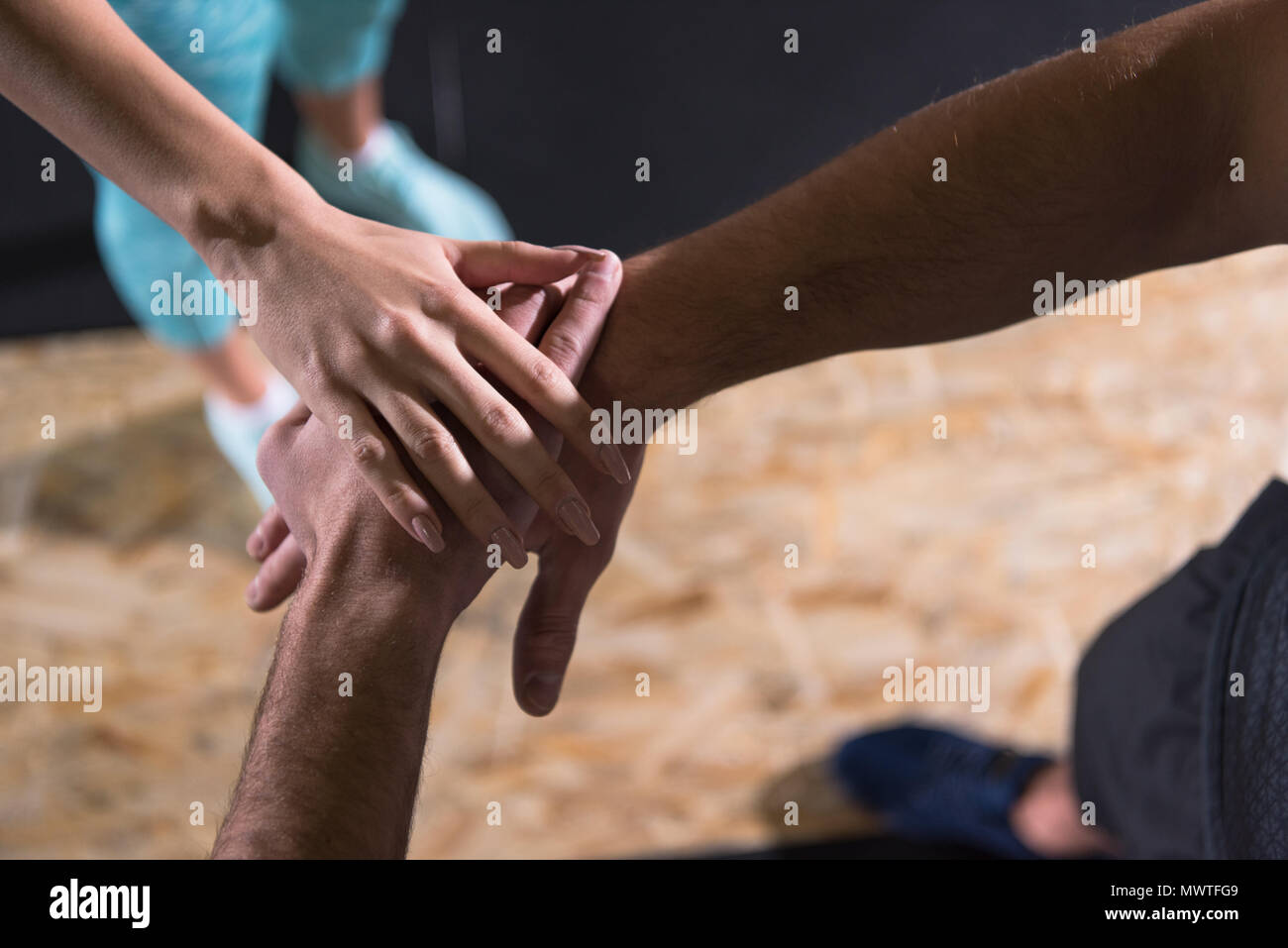 group of young athletes making high five after hard exercise at cross ...