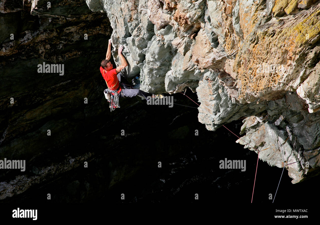 A rock climber in action on an extreme route on the cliffs of Gogarth ...