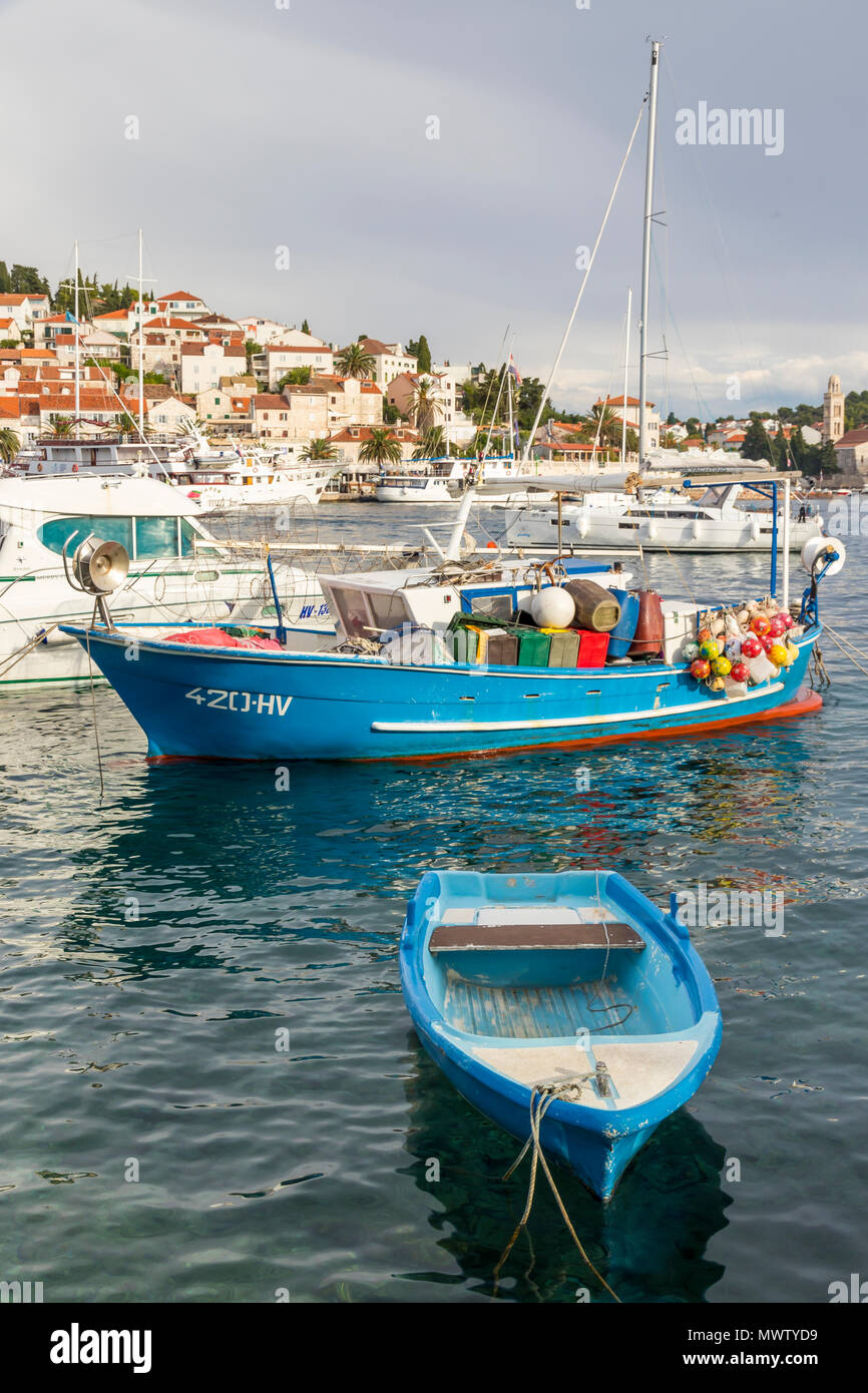 Colorful boat anchoring in the port of Hvar Town with view to the old ...