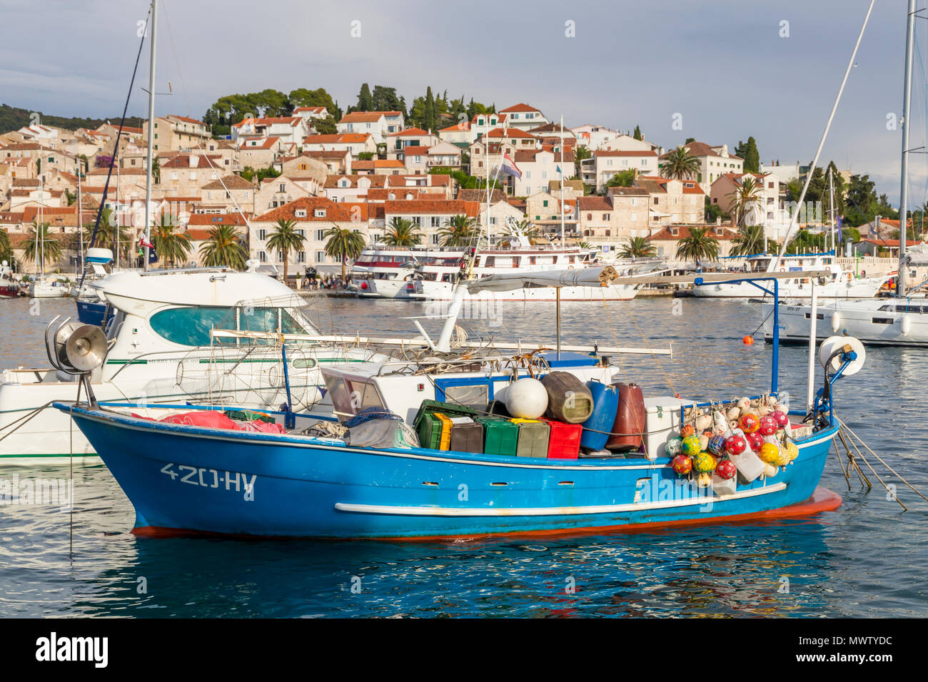 Colorful boat anchoring in the port of Hvar Town with view to the old ...
