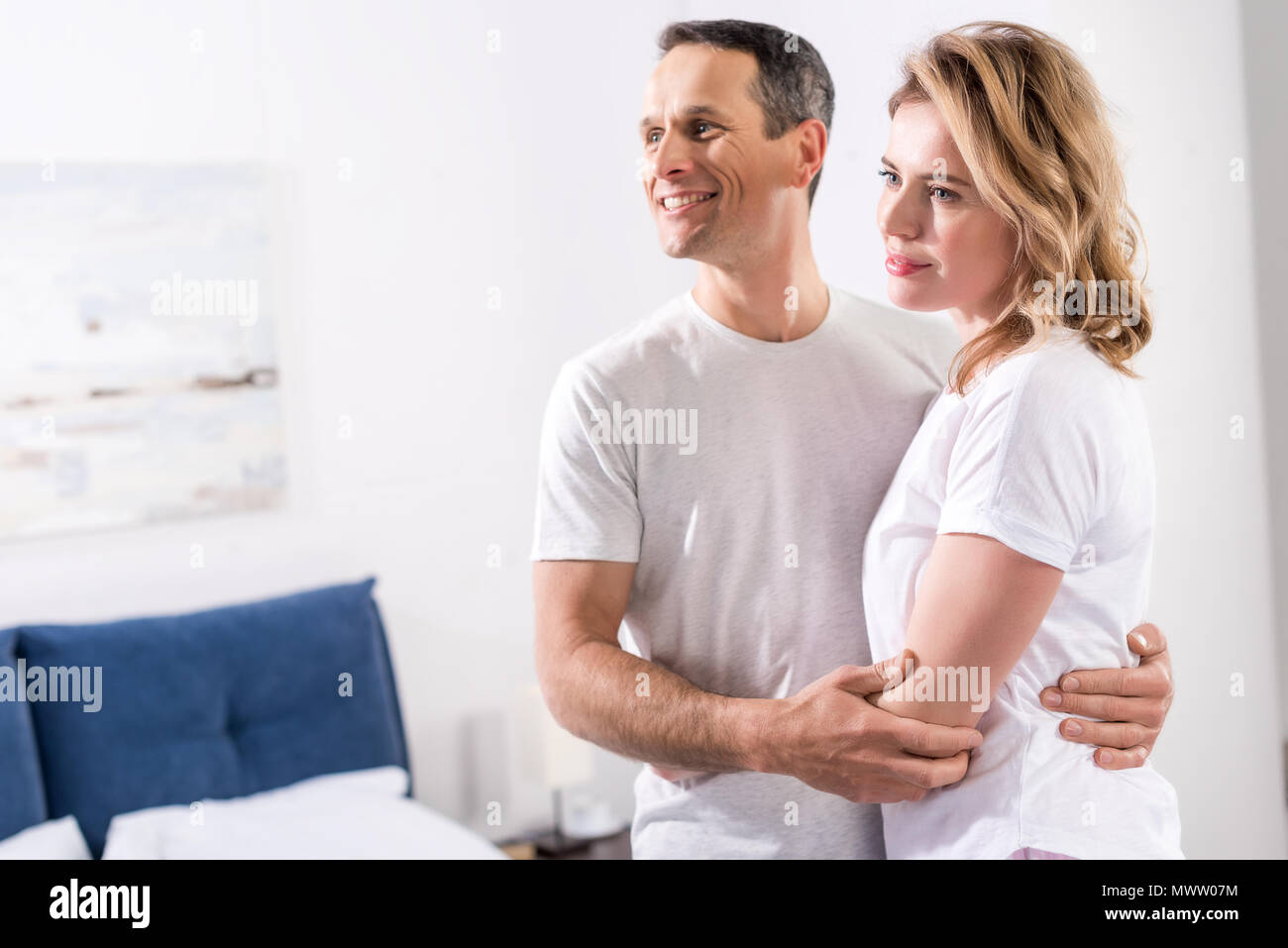 Portrait Of Smiling Husband And Wife Hugging Each Other In Bedroom At