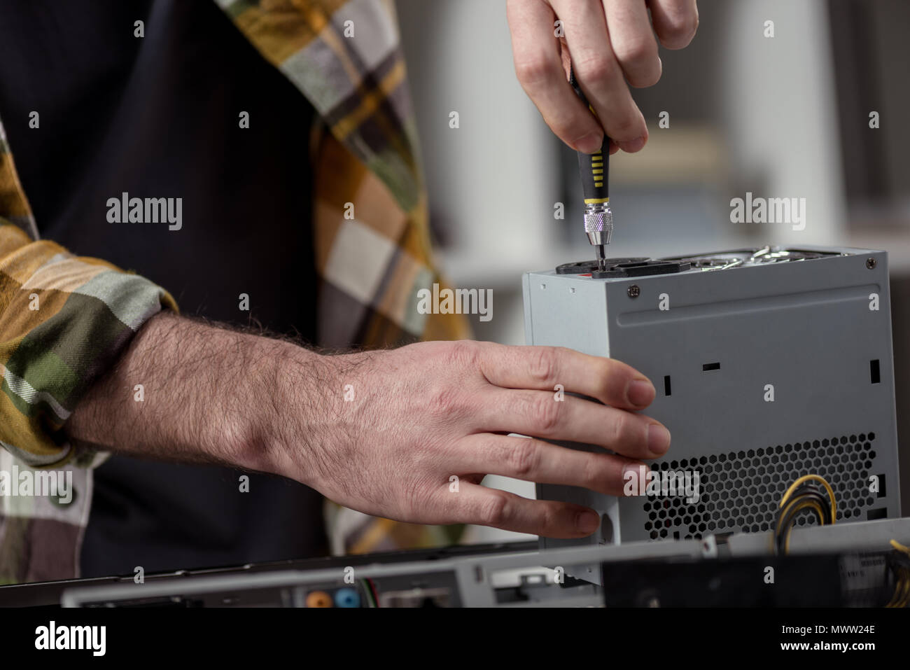man using screwdriver while fixing computer detail Stock Photo - Alamy