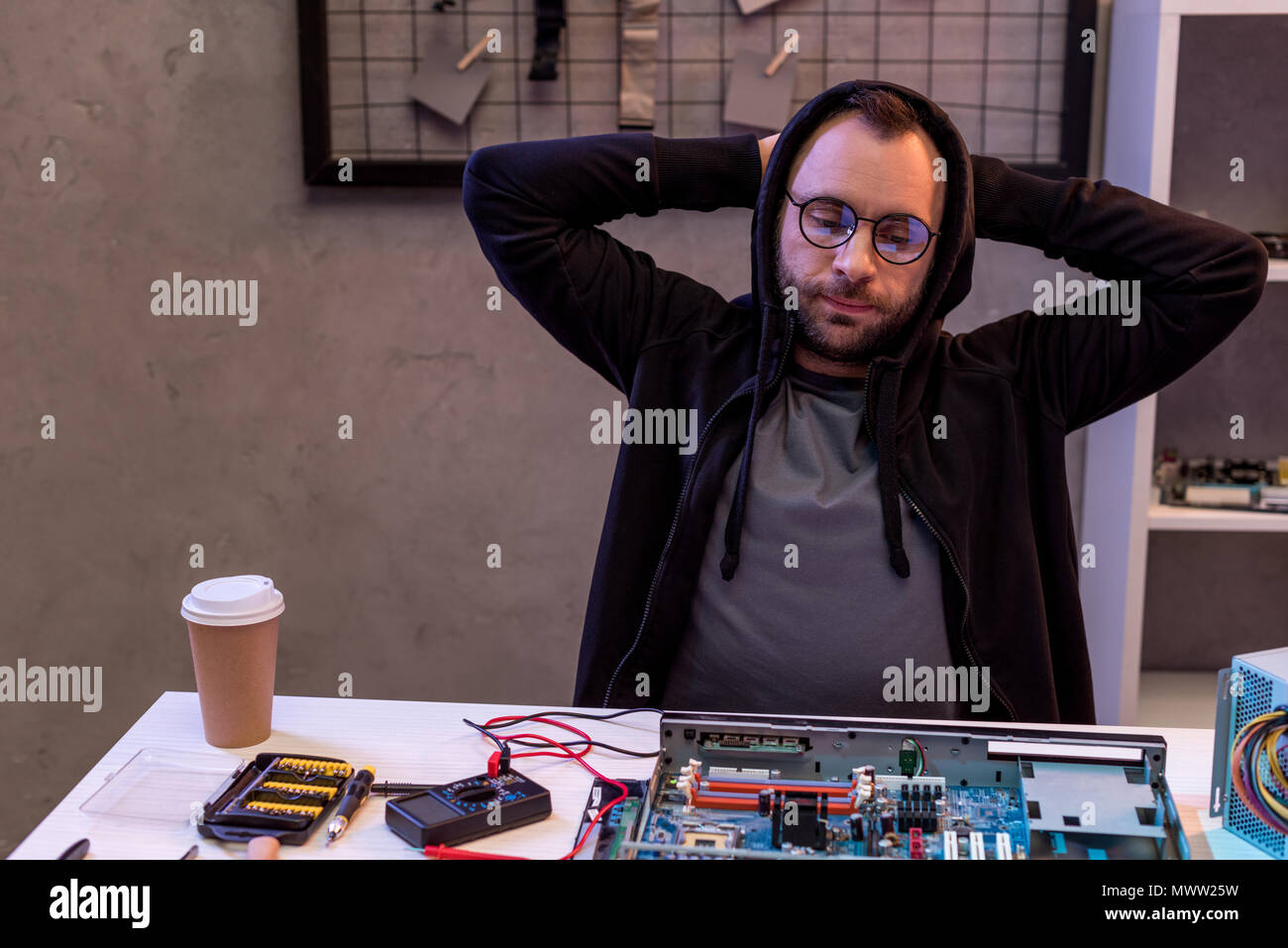 man with hands behind head looking on computer motherboard Stock Photo ...