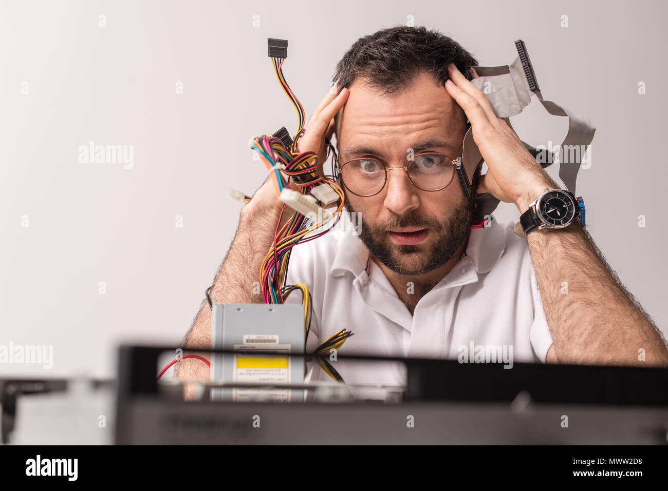 scared man with wires in hands near his head looking on broken pc Stock ...
