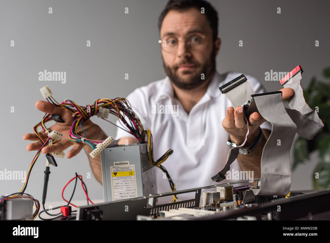bewildered man holding wires in outstretched hands Stock Photo - Alamy