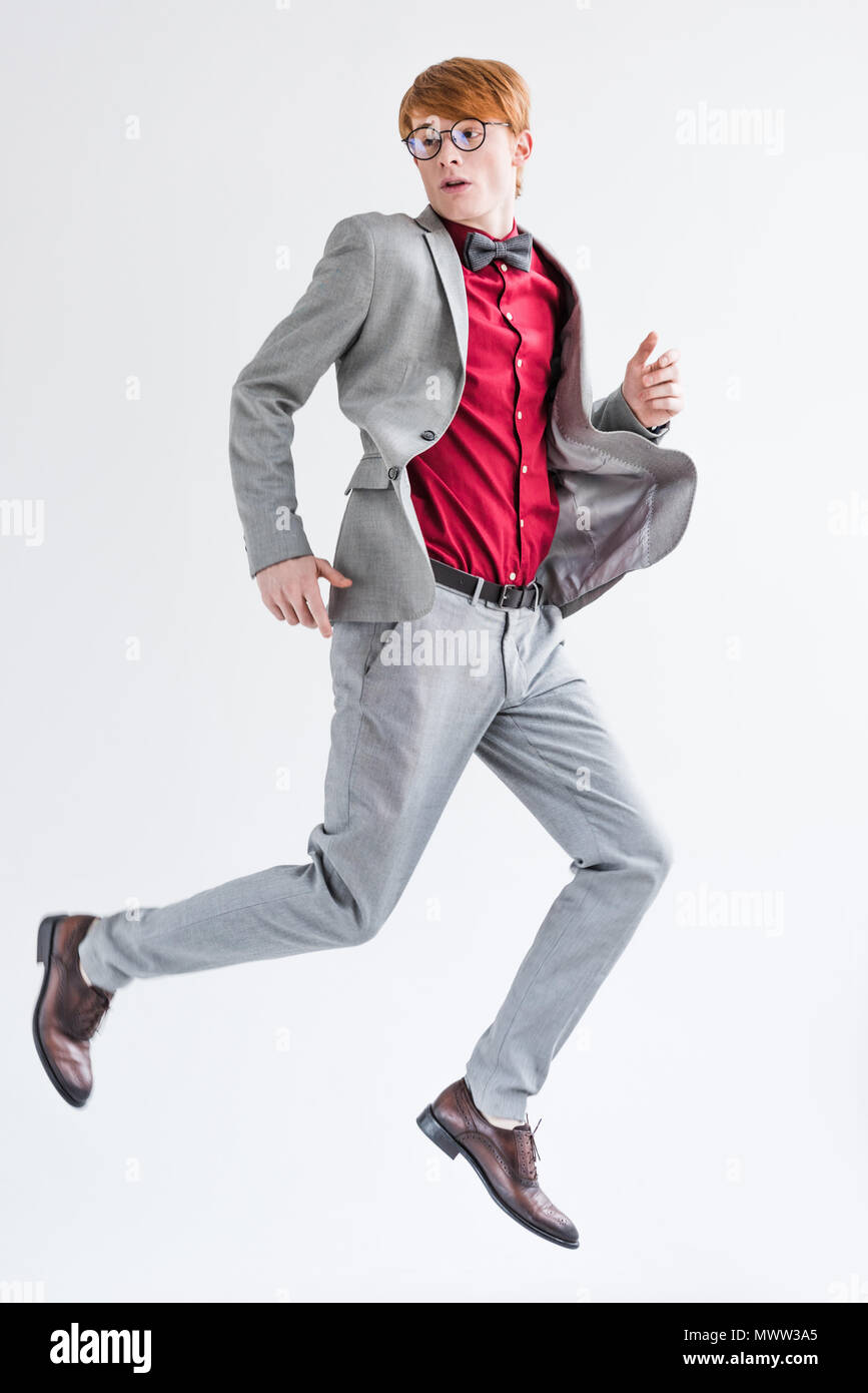 Jumping male fashion model dressed in suit isolated on grey Stock Photo ...