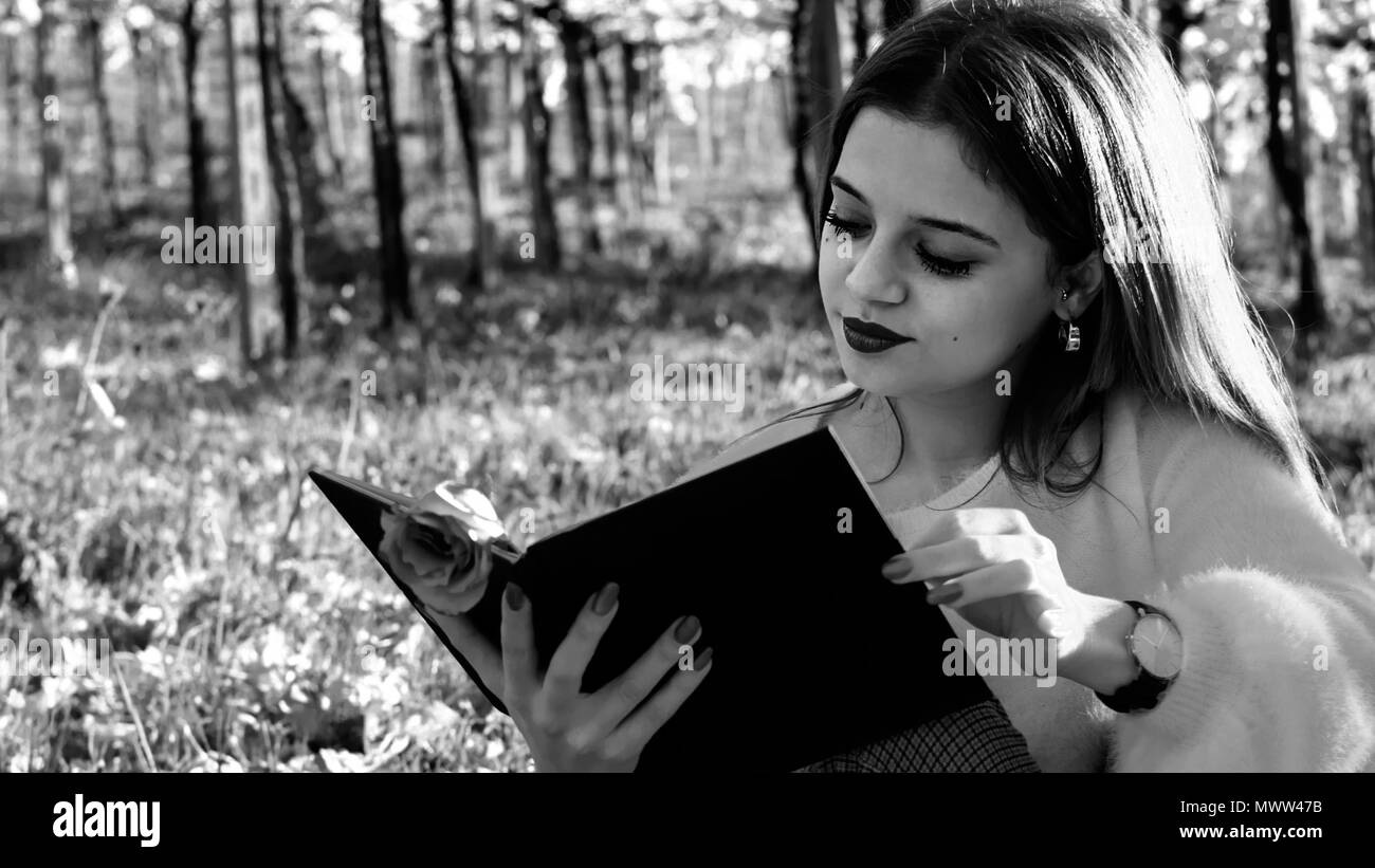 Girl reading a book sitting in the nature Stock Photo - Alamy