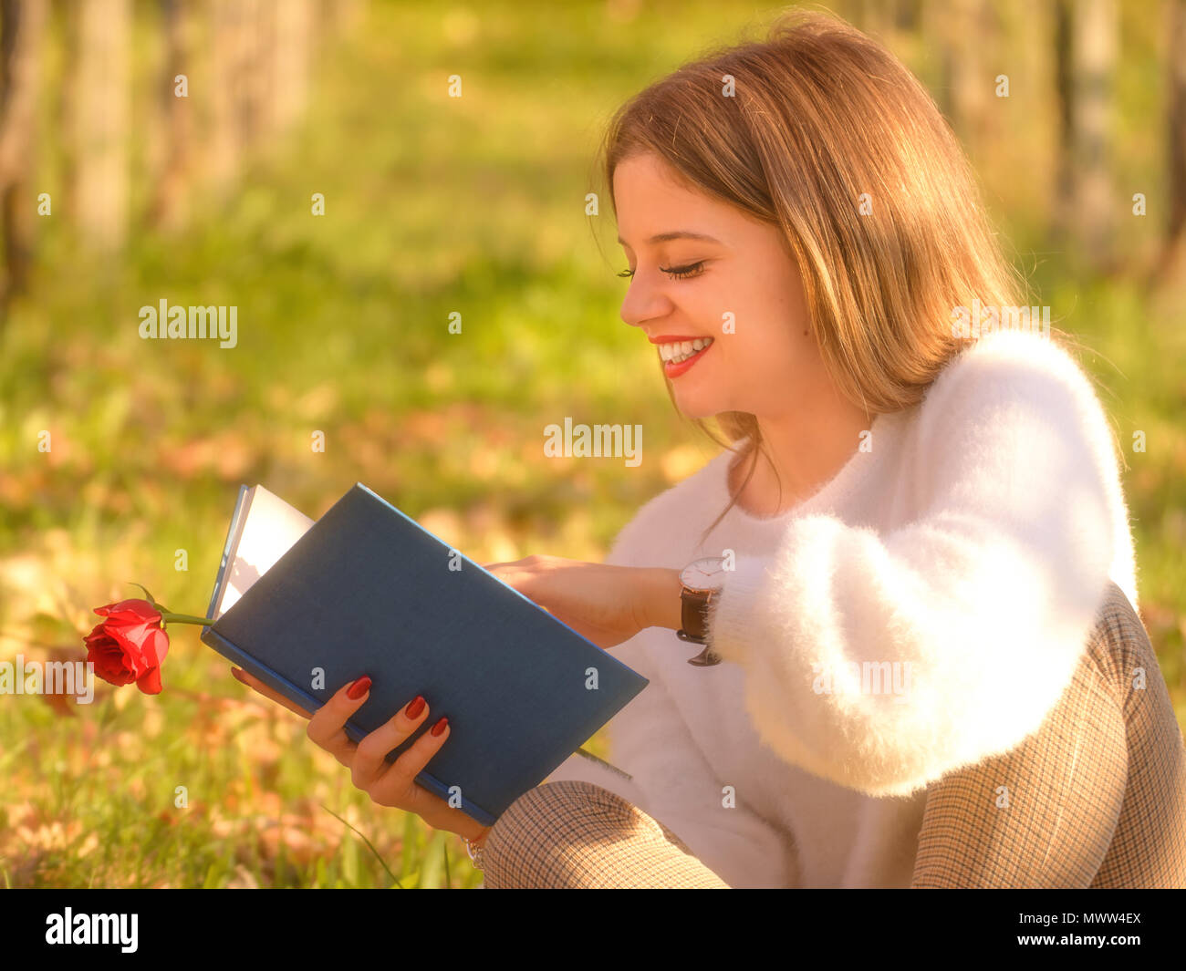 Girl reading a book sitting in the nature Stock Photo - Alamy