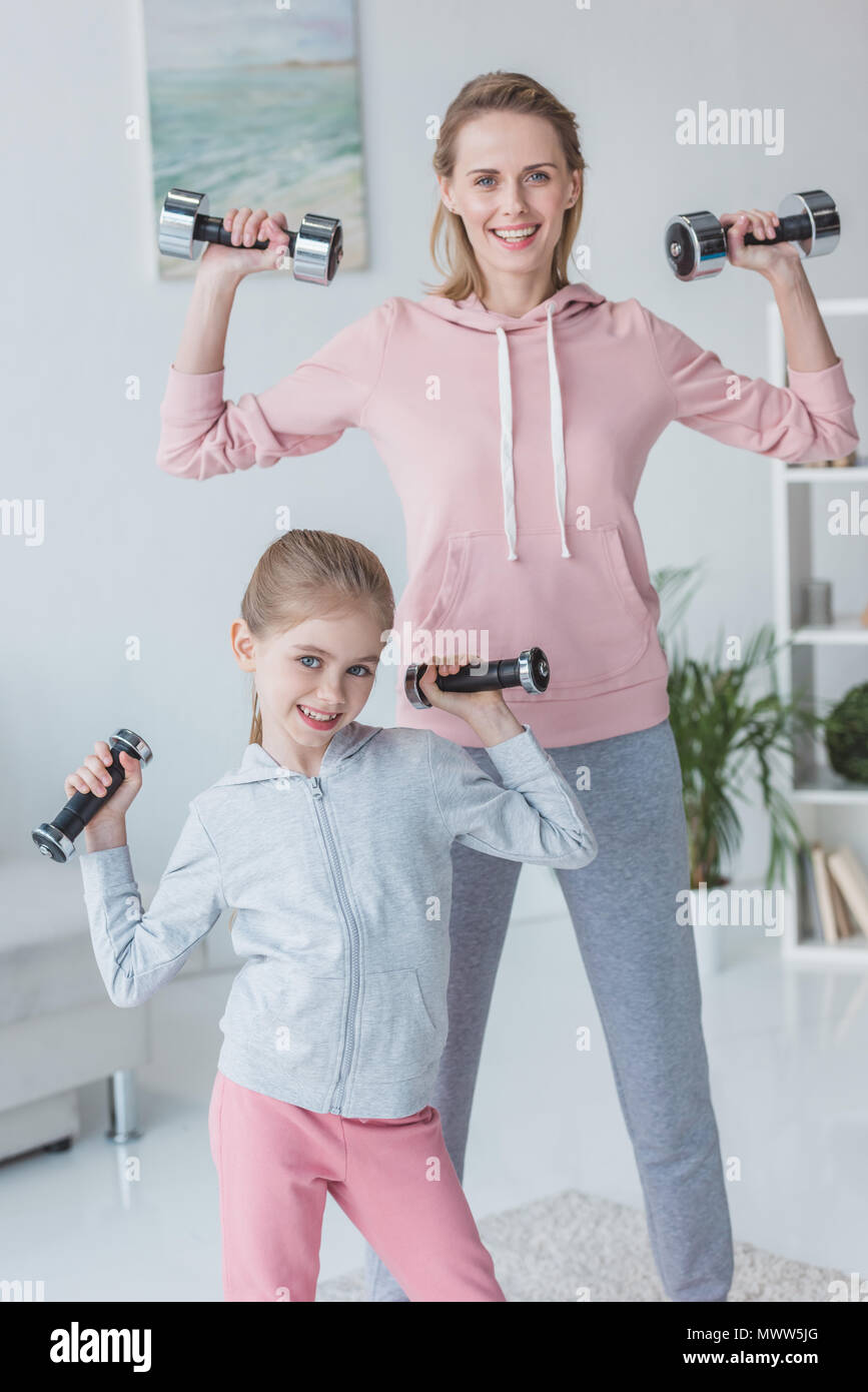 healthy mother and daughter working out with dumbbells at home Stock ...