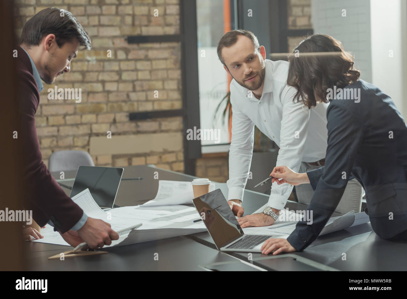 team of young architects brainstorming on building plans Stock Photo ...