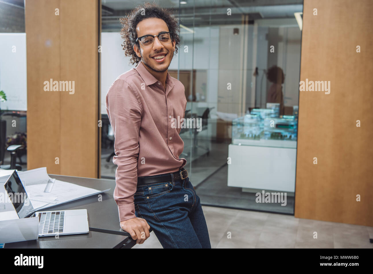 handsome young architect leaning back on workplace at office Stock ...