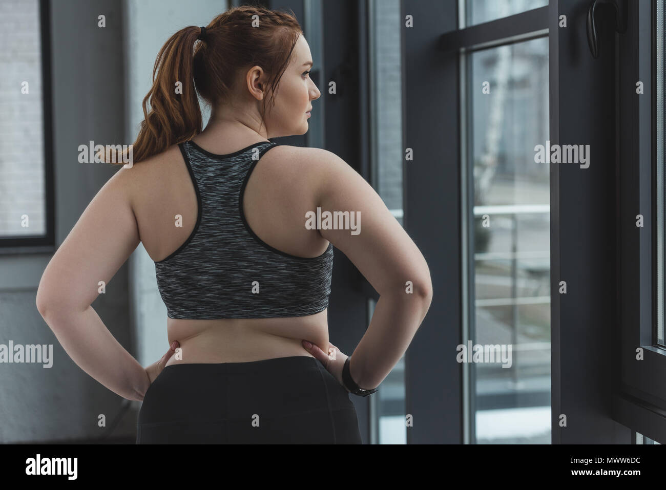 Obese girl wearing sports top in gym Stock Photo - Alamy