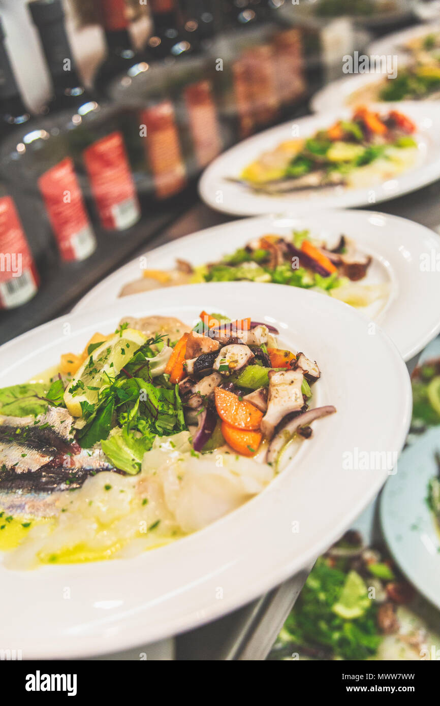 Seafood salad in a line to be served Stock Photo - Alamy