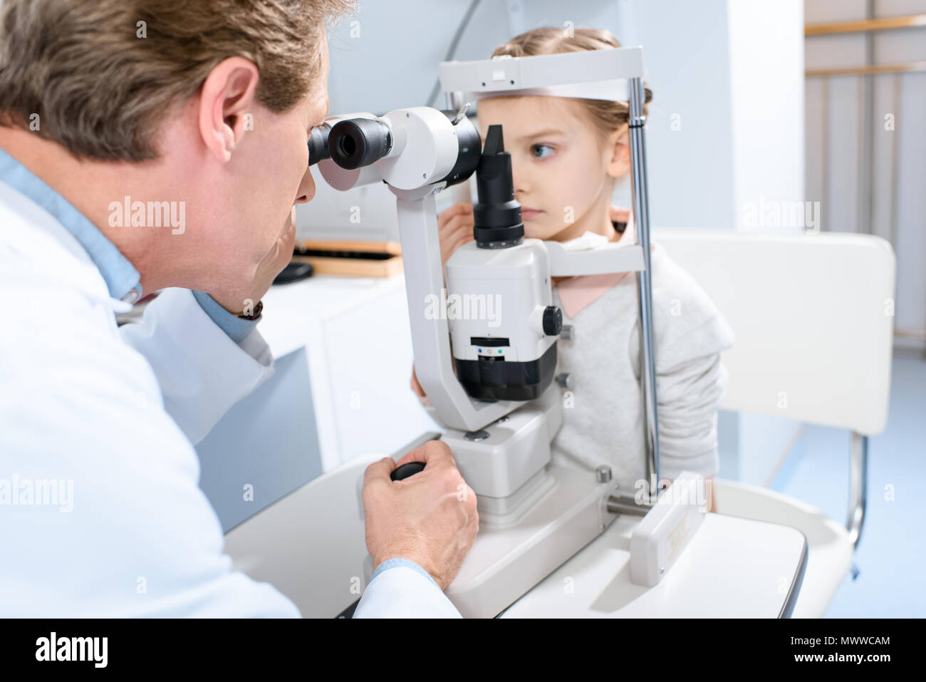 ophthalmologist examining vision of preteen kid with slit lamp in ...