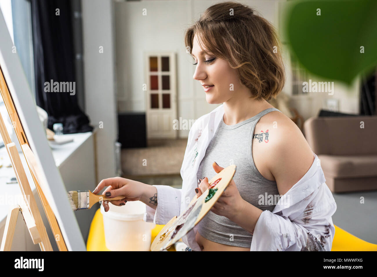 Young creative girl painting on canvas in light studio Stock Photo - Alamy