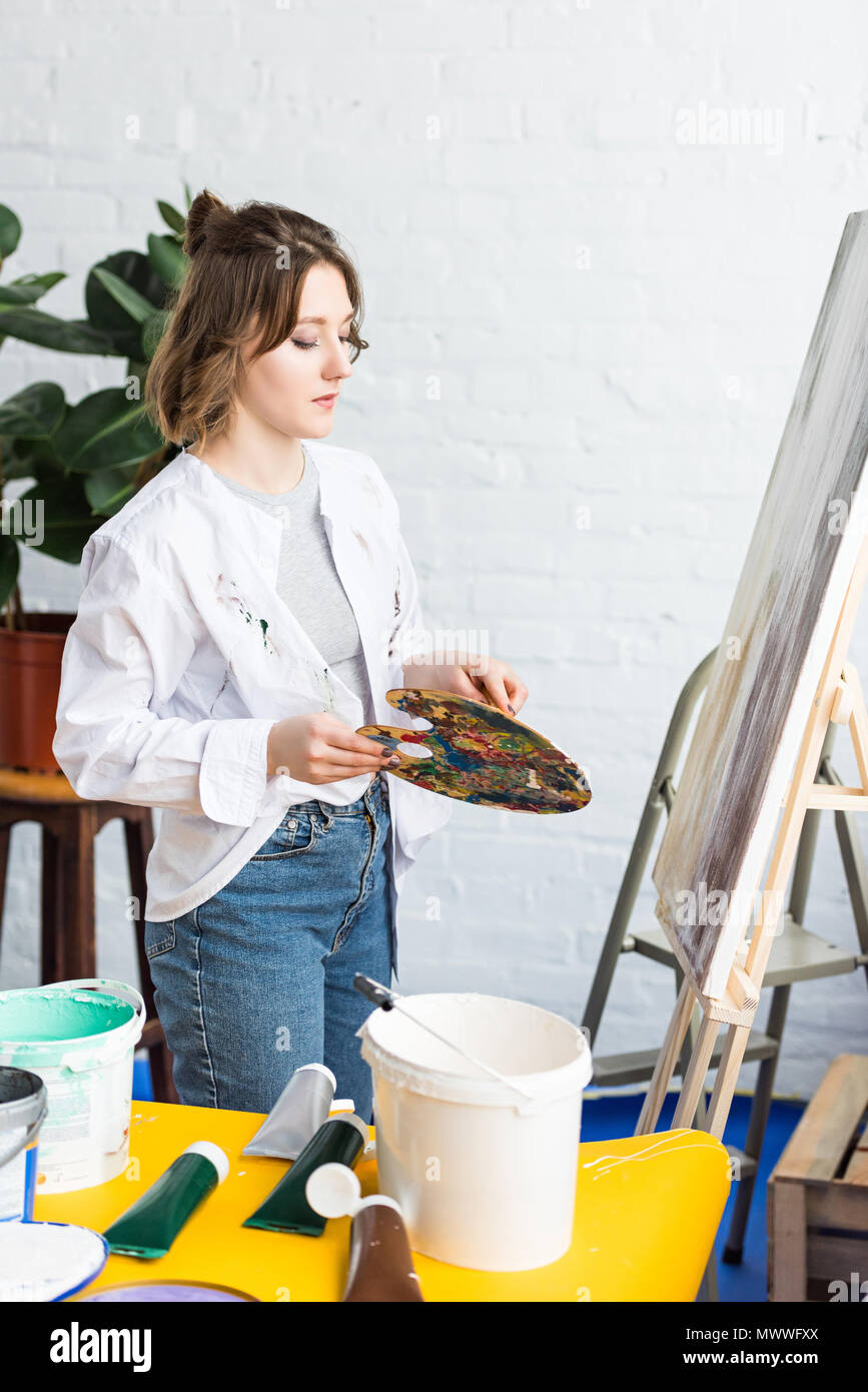 Young artistic girl with palette in light studio Stock Photo - Alamy