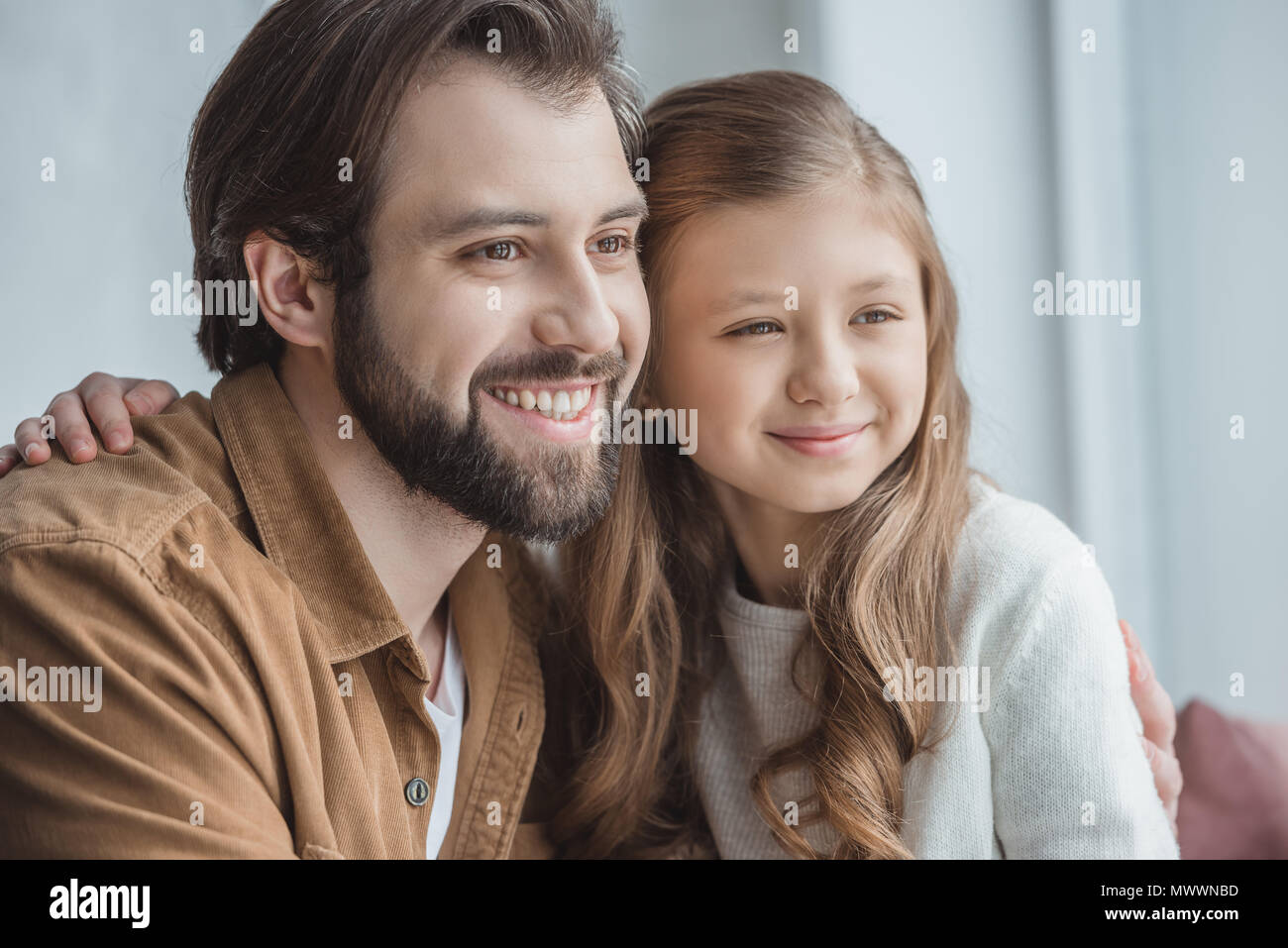 smiling father and daughter looking away at window Stock Photo - Alamy
