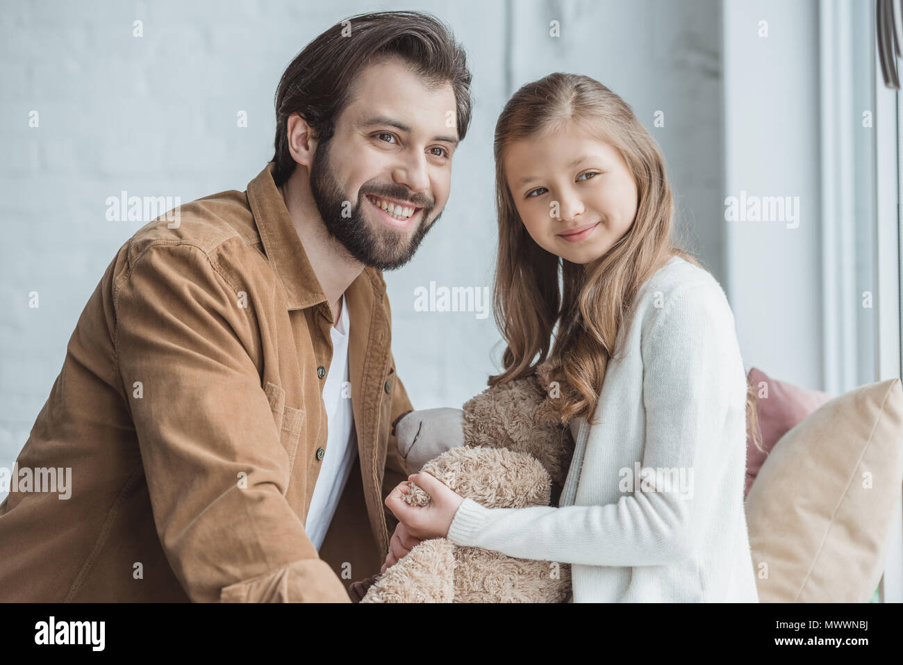 happy father and daughter looking away at window Stock Photo - Alamy