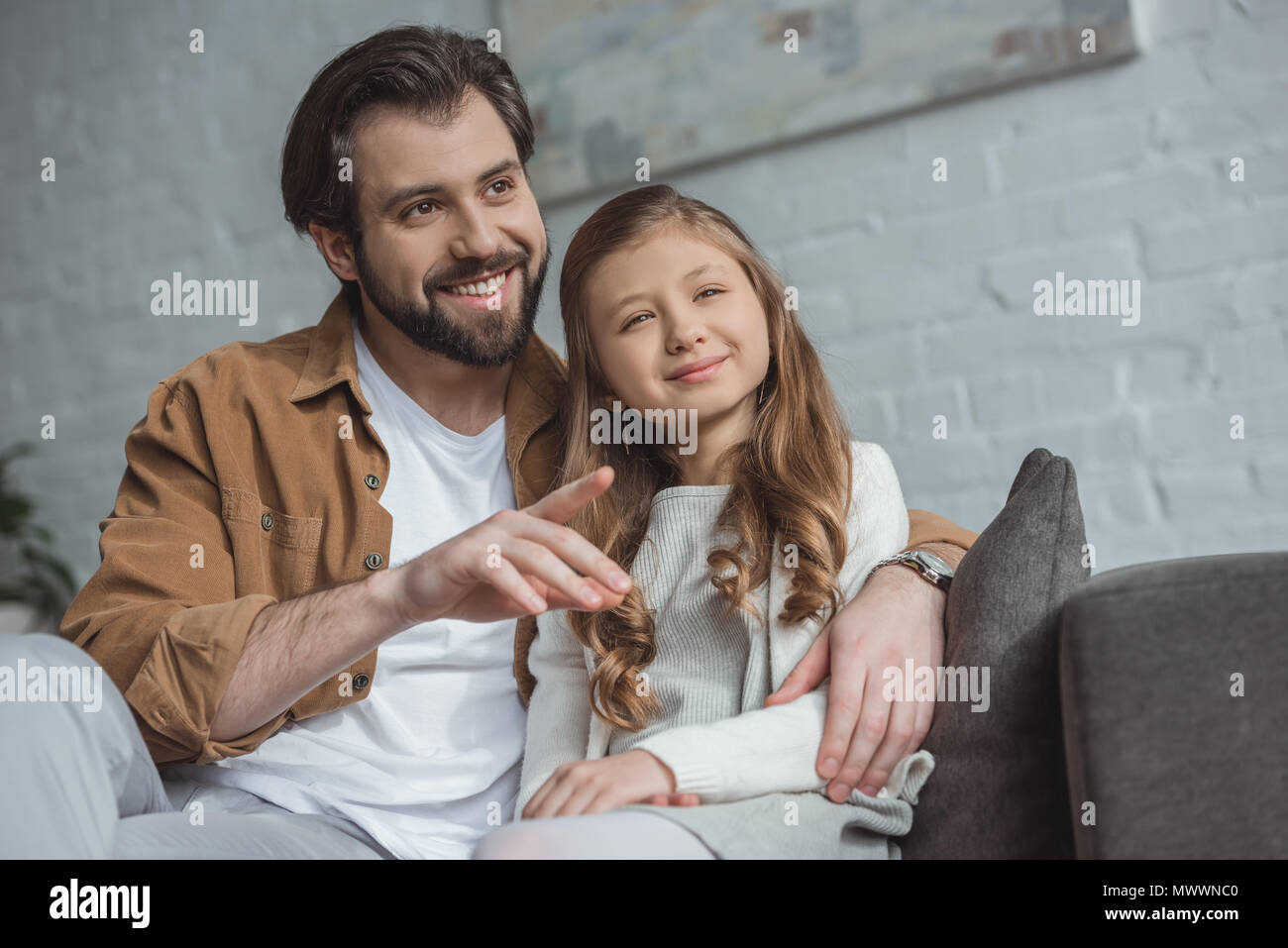 smiling father pointing on something to daughter at home Stock Photo ...