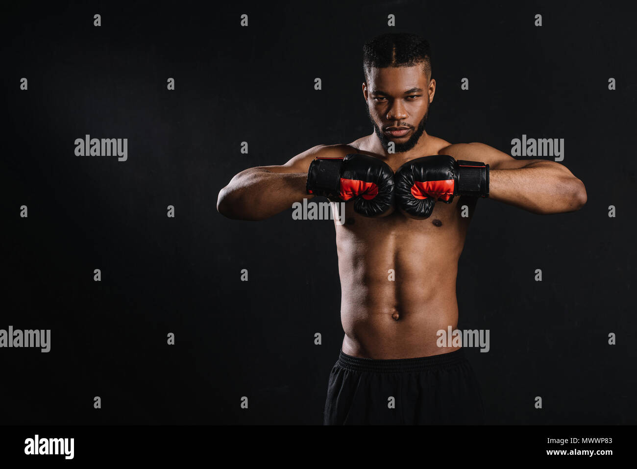 muscular shirtless african american boxer in boxing gloves looking at ...