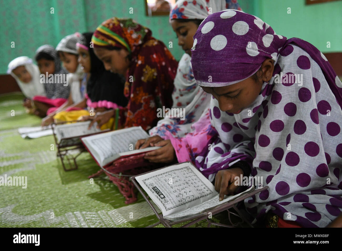 Muslim young girls seen reading the Quran together. Children gathered ...