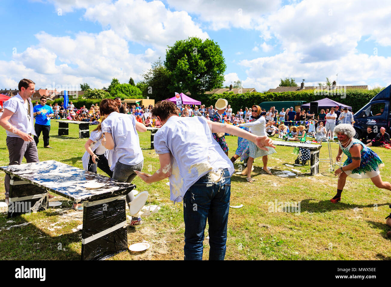 Two teams of four people each throwing custard pies at each other ...