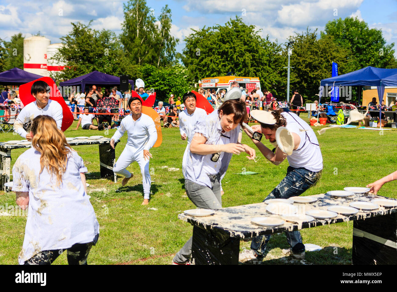 Two teams of four people each throwing custard pies at each other ...
