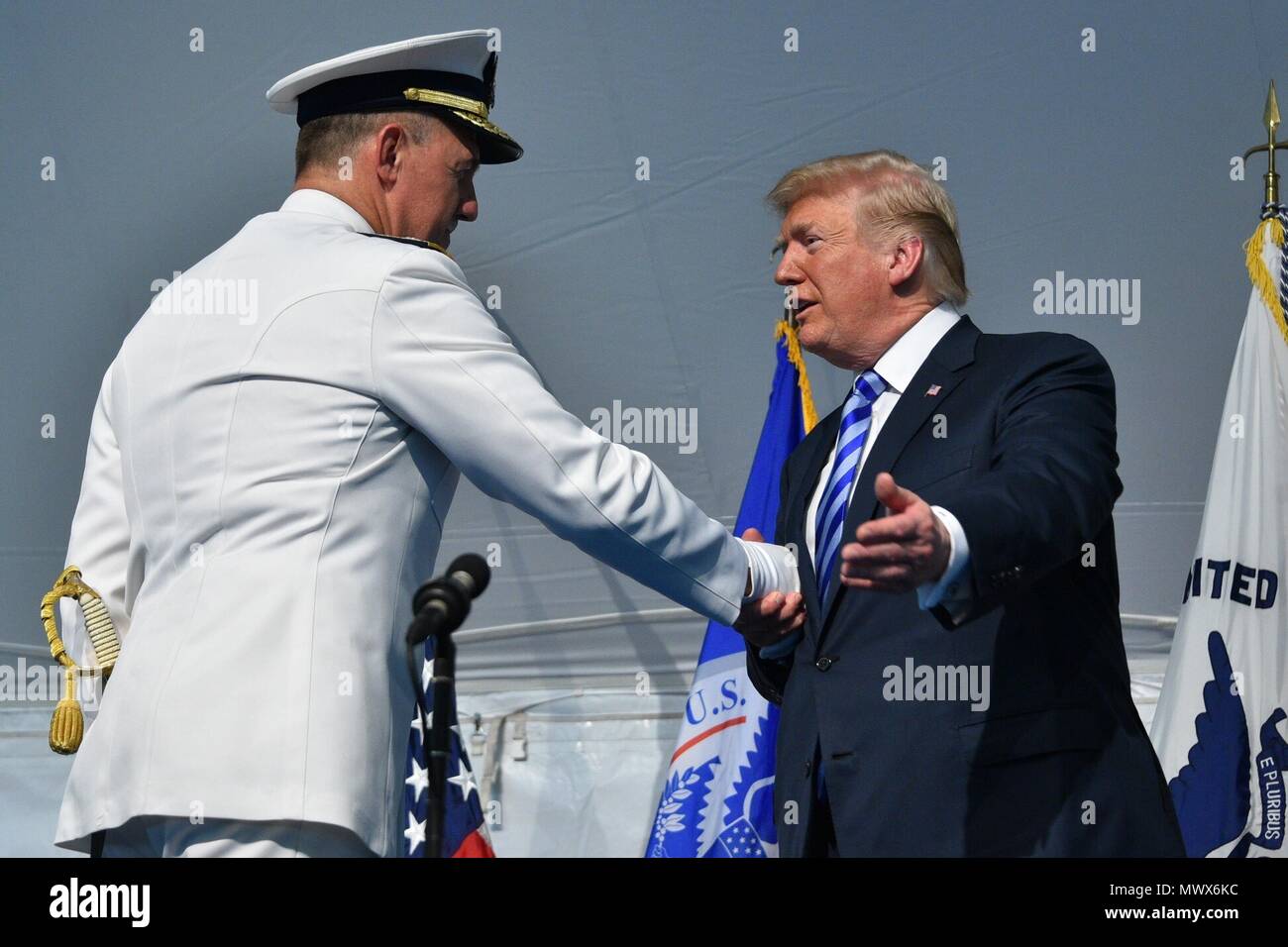 U.S. President Donald Trump congratulates Adm. Karl Schultz, left ...