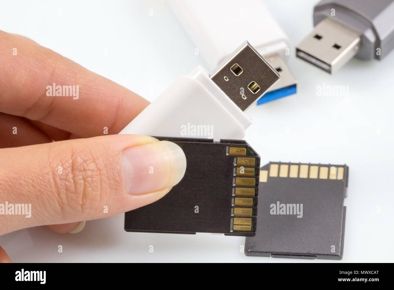 Hand holding usb stick, usb flash drive and memory card on white ...