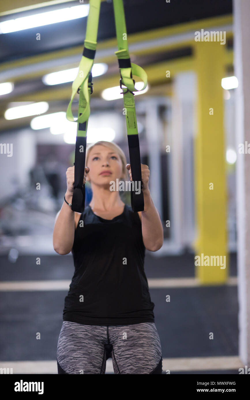 young athlete woman working out pull ups with gymnastic rings at the ...