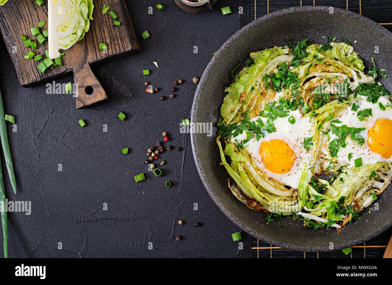 Fried eggs with slices of young cabbage and greens. Nutritious ...
