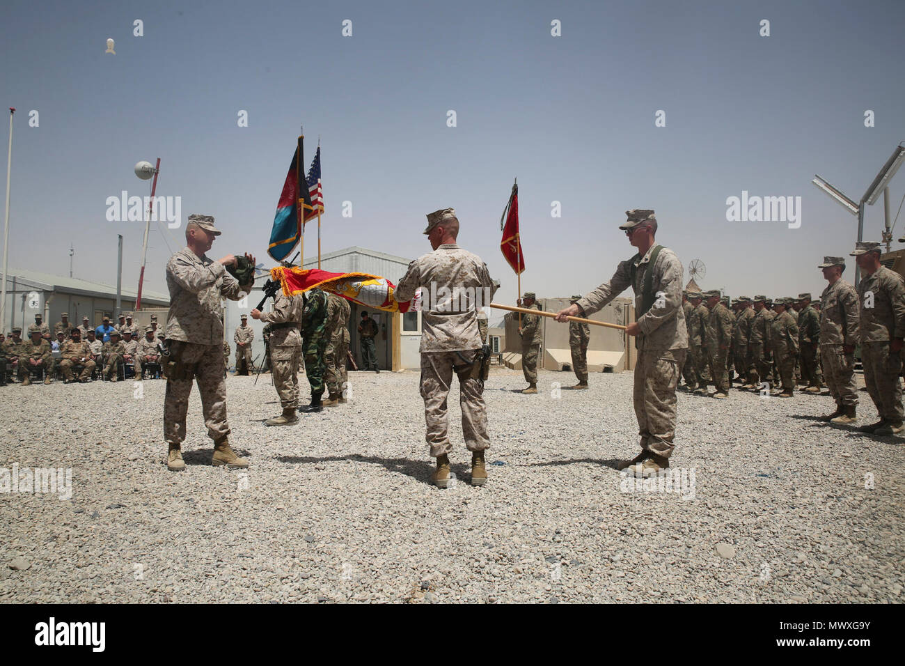 Col. Matthew Reid, left, and Sgt. Maj. Darrell Carver, center, unfurl ...
