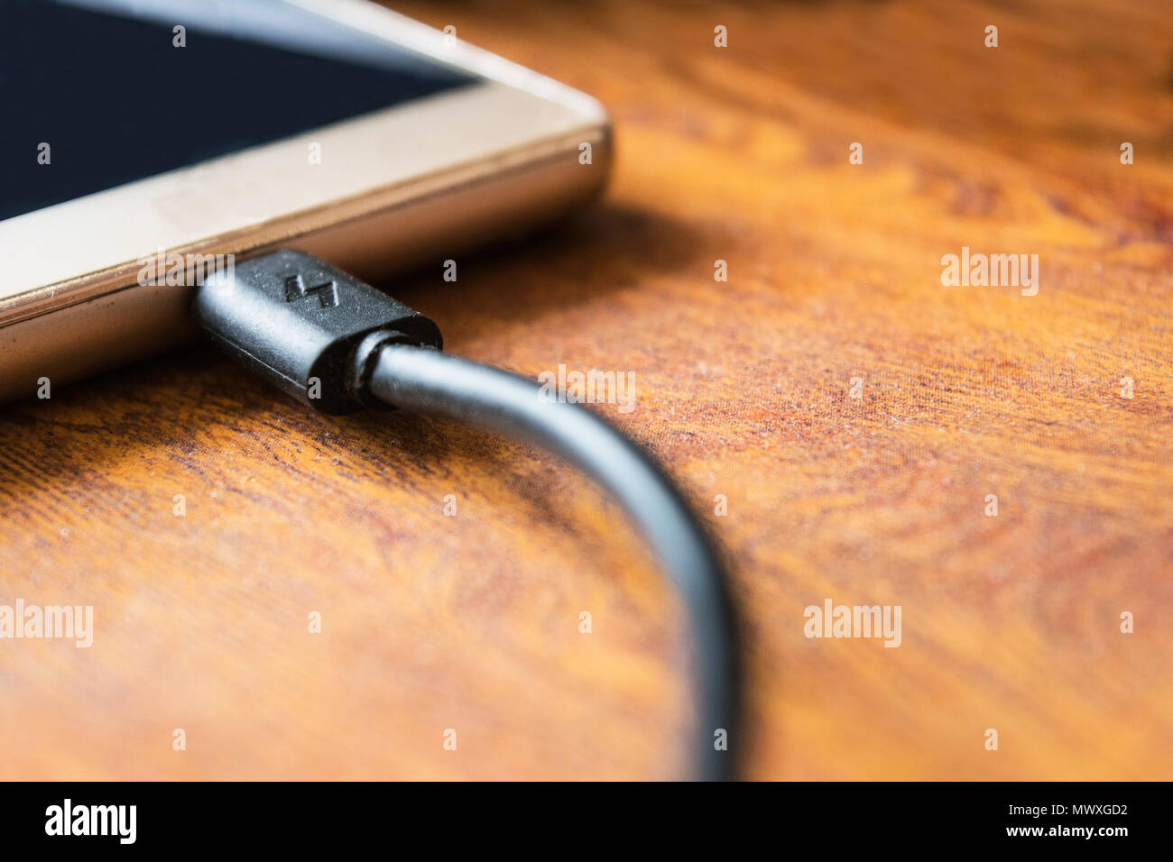 Charger plug phone on wooden table background Stock Photo - Alamy