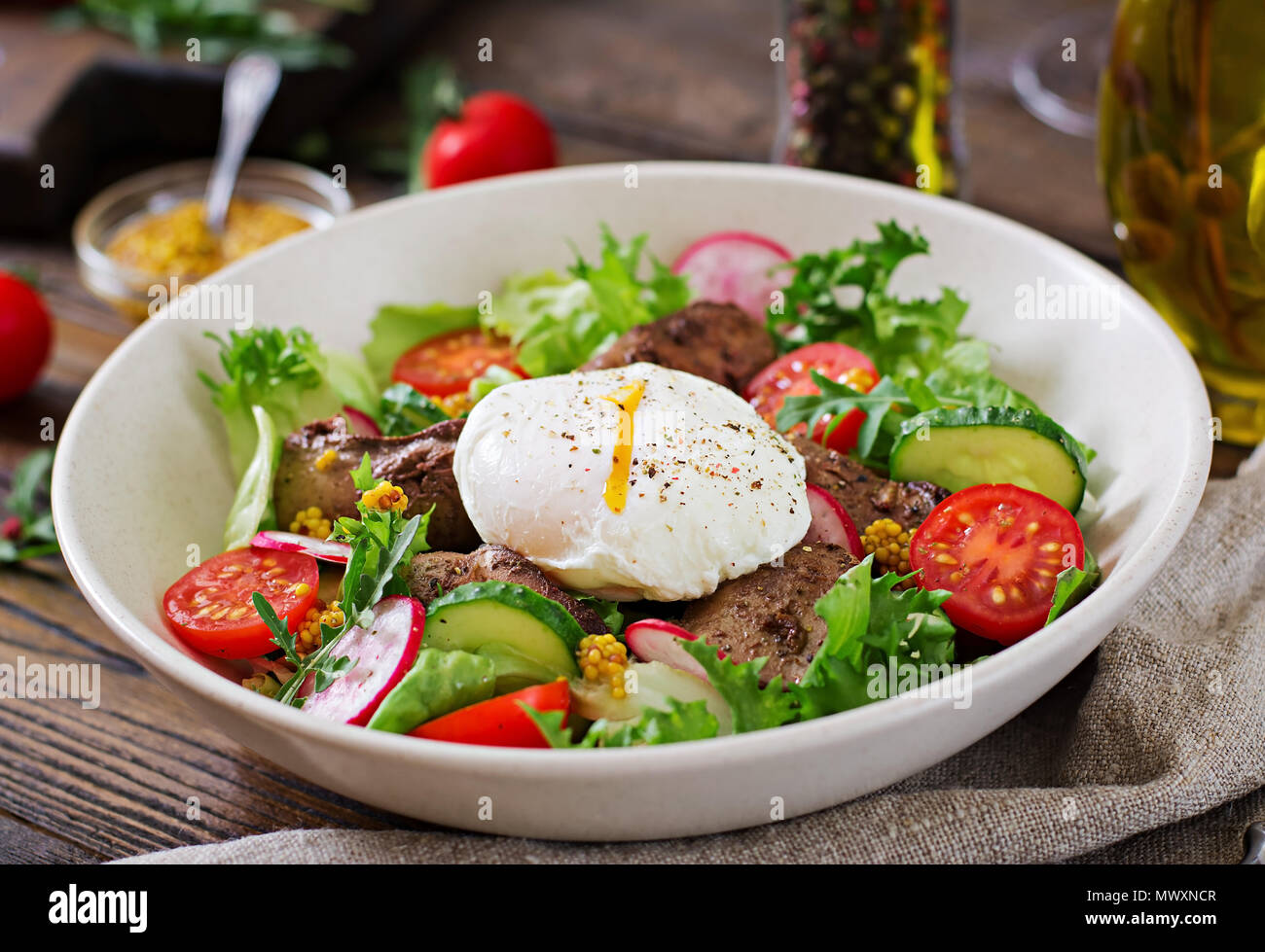 Warm salad from chicken liver, radish, cucumber, tomato and egg poached ...
