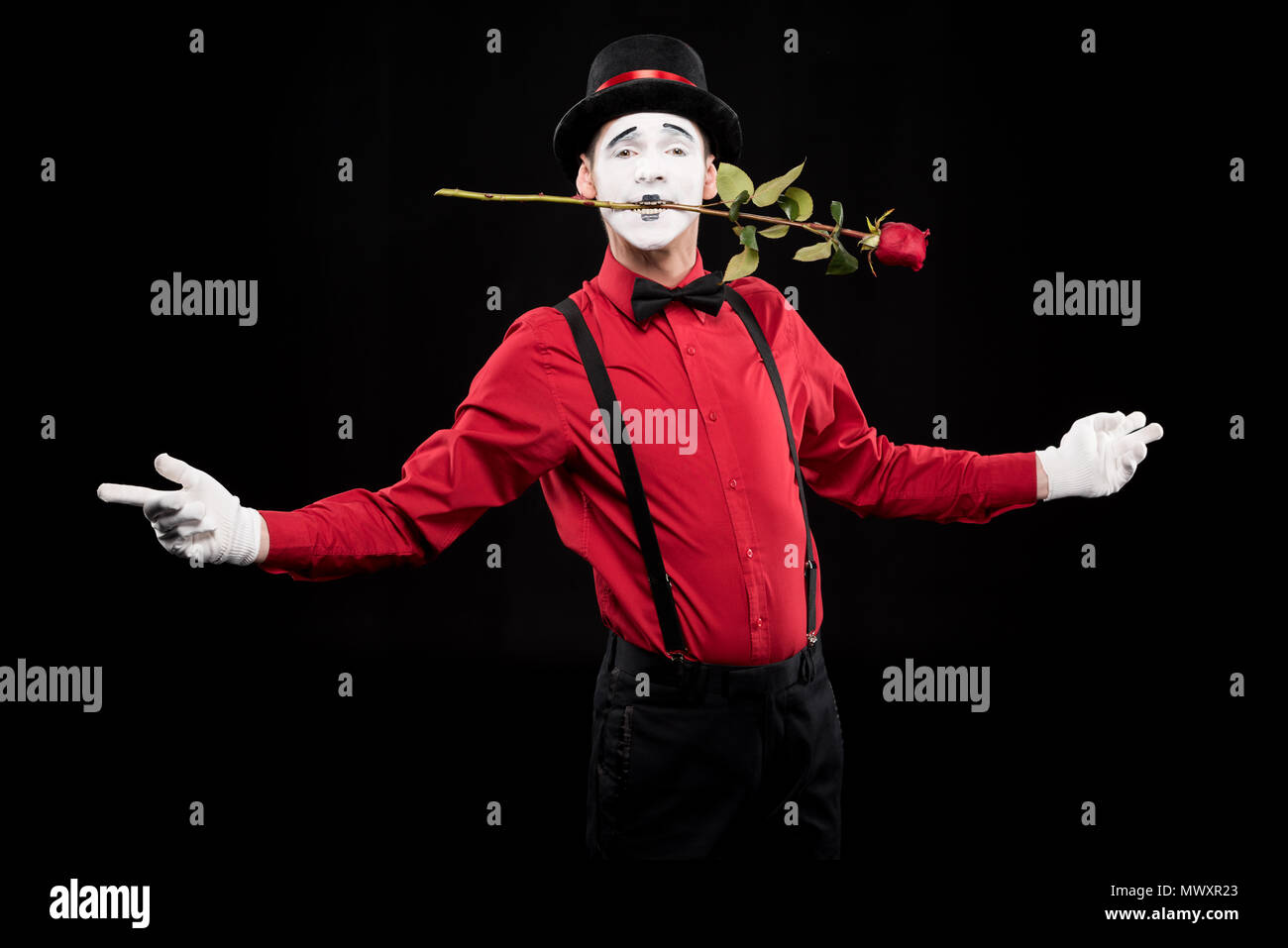 mime holding red rose in mouth and standing with open arms isolated on ...