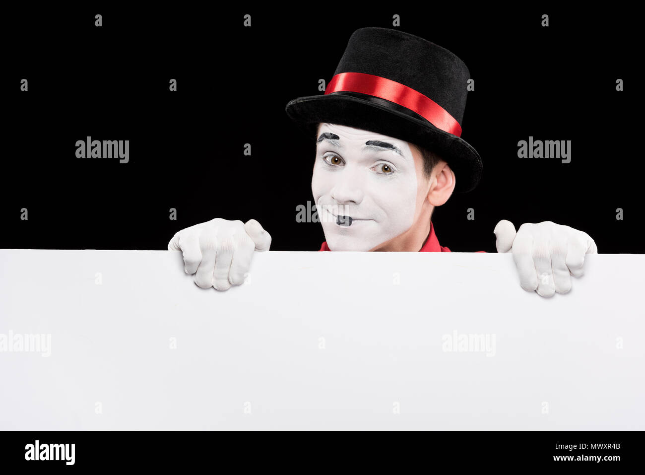 happy mime looking out from empty board isolated on black Stock Photo ...