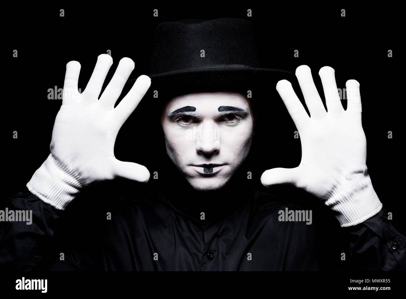 mime showing hands isolated on black Stock Photo - Alamy