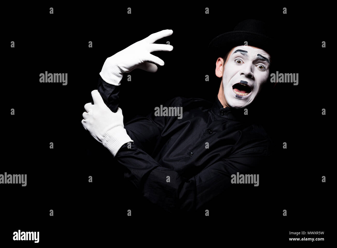 scared mime with hand monster looking at camera isolated on black Stock ...