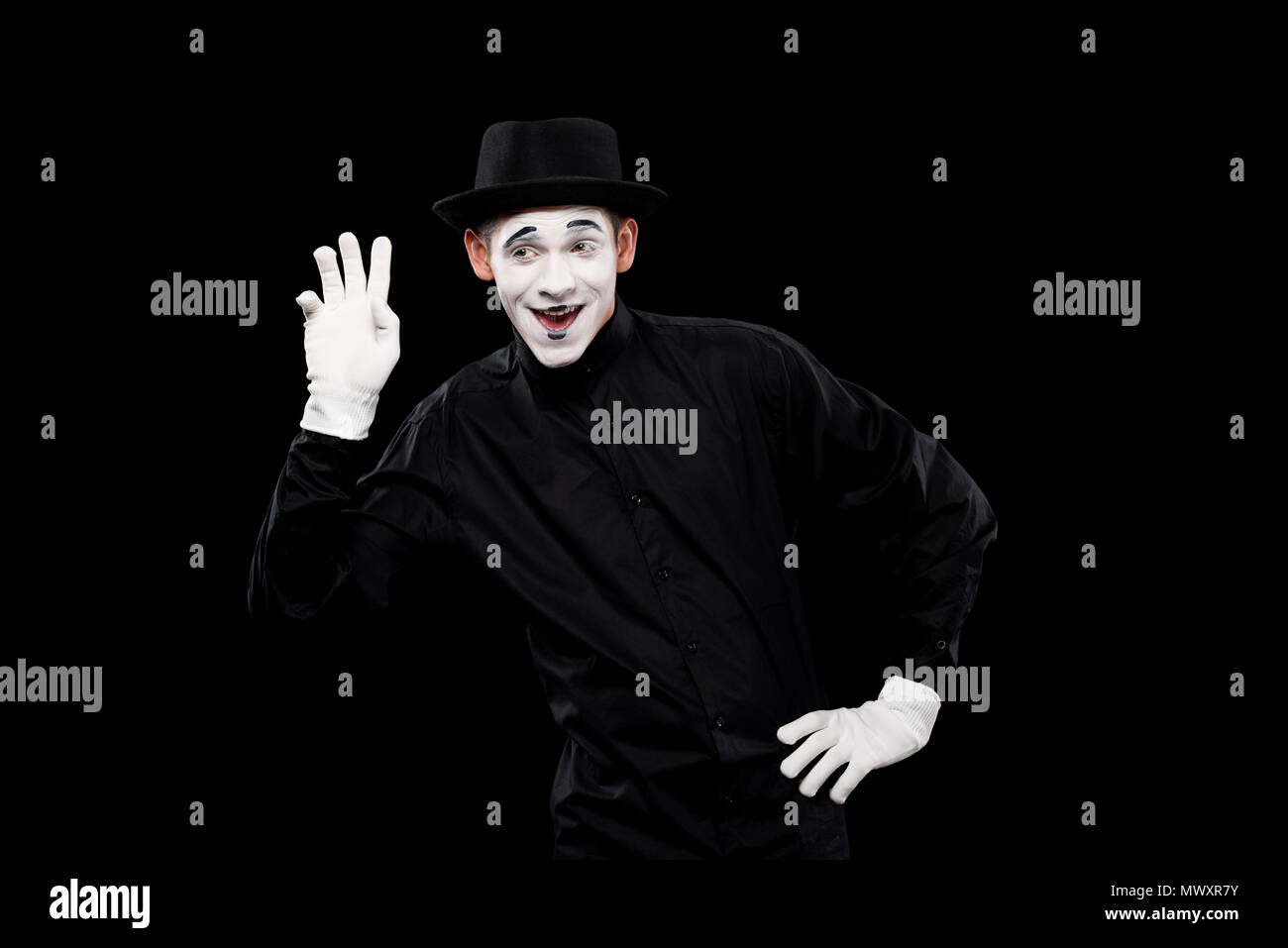 happy mime waving hand isolated on black Stock Photo - Alamy