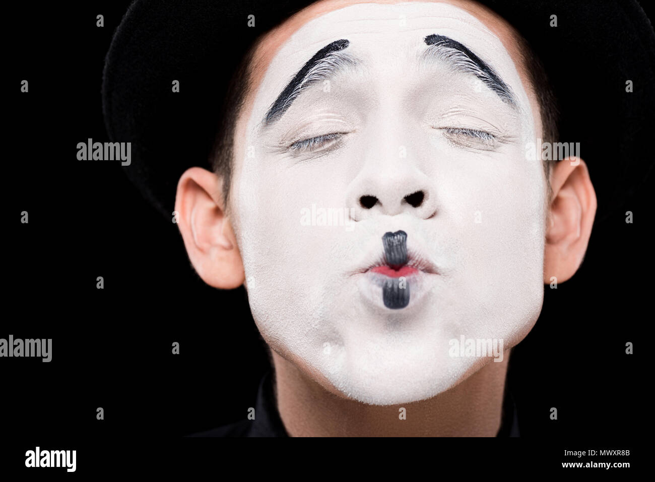 mime showing kiss with closed eyes isolated on black Stock Photo - Alamy
