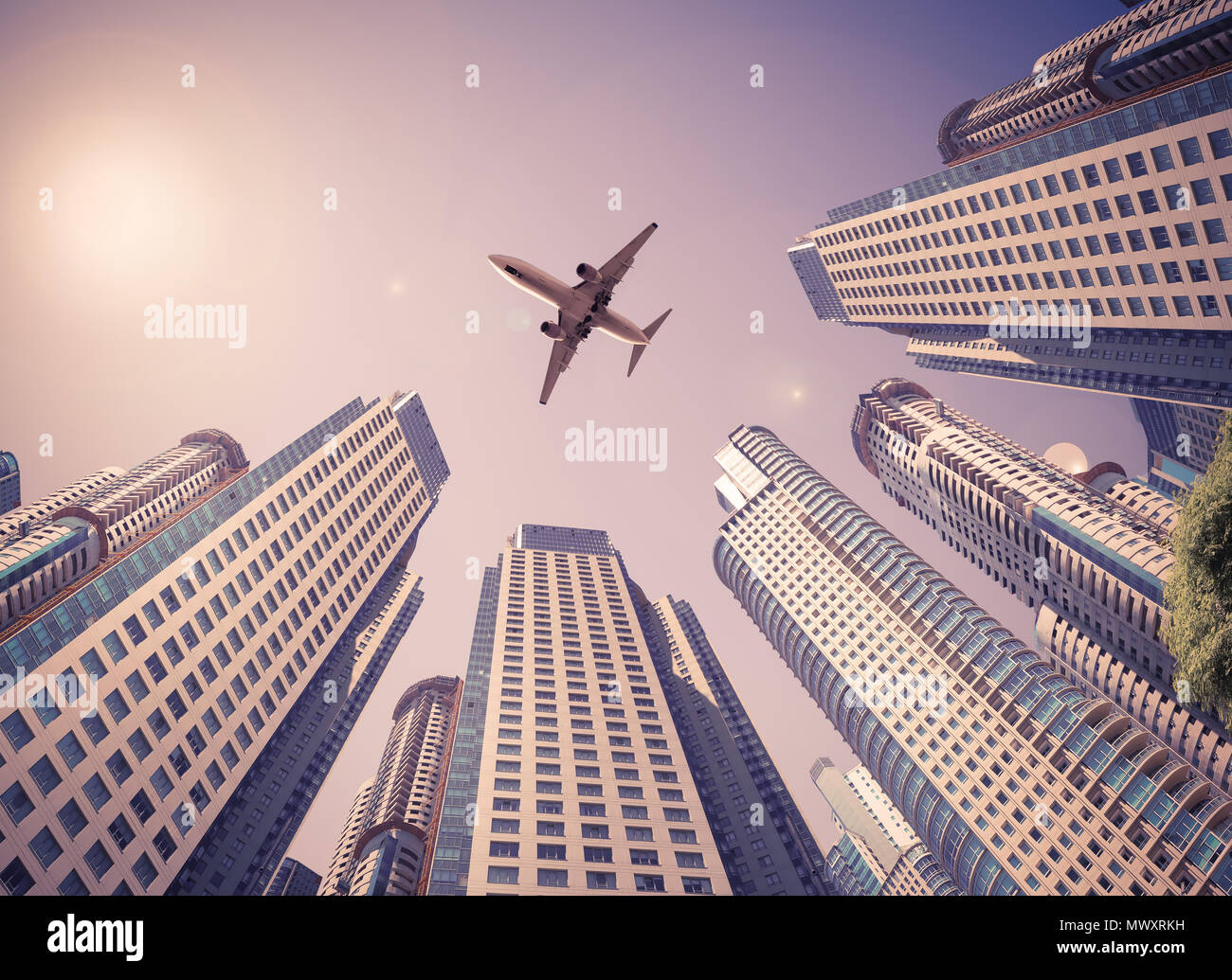 Plane soaring high in the sky encircled by skyscrapers Stock Photo - Alamy
