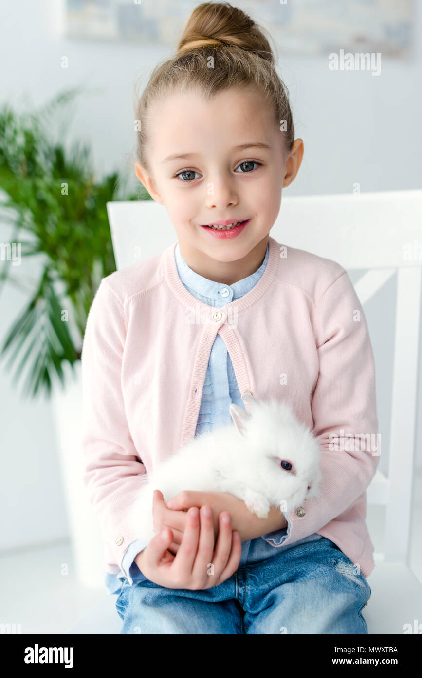 White rabbit sitting on knees of child girl Stock Photo - Alamy