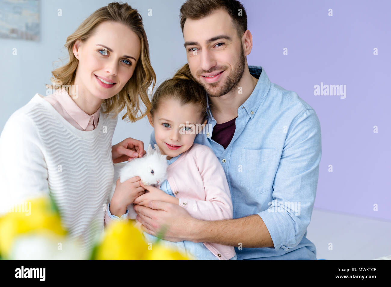 Happy family holding white rabbit Stock Photo - Alamy