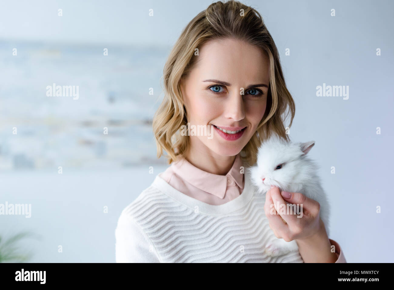 Blonde woman holding white rabbit Stock Photo - Alamy