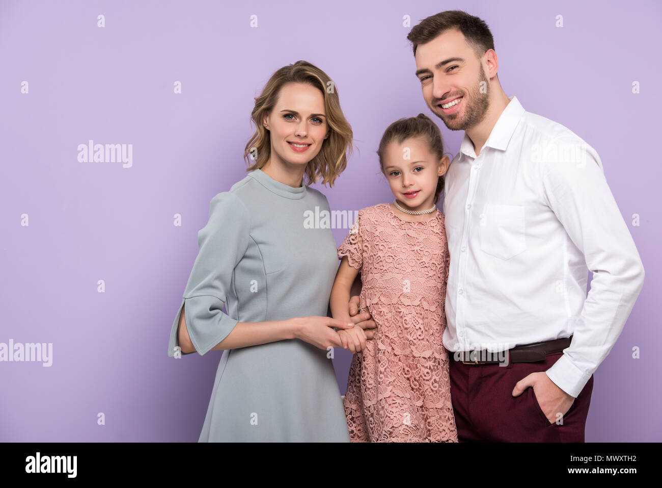 Adorable family with daughter isolated on violet Stock Photo - Alamy