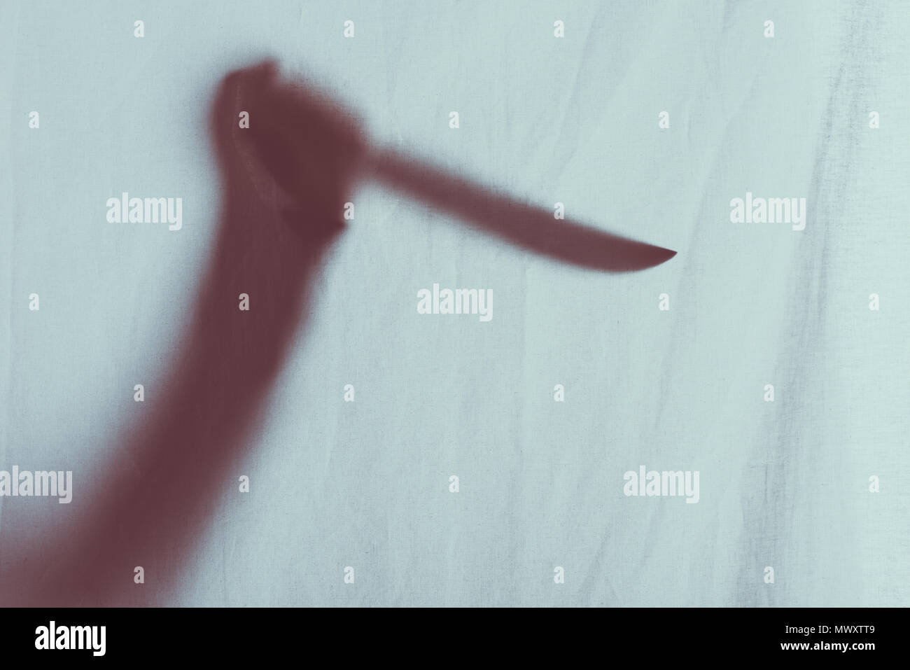 scary blurry silhouette of person holding knife behind veil Stock Photo ...